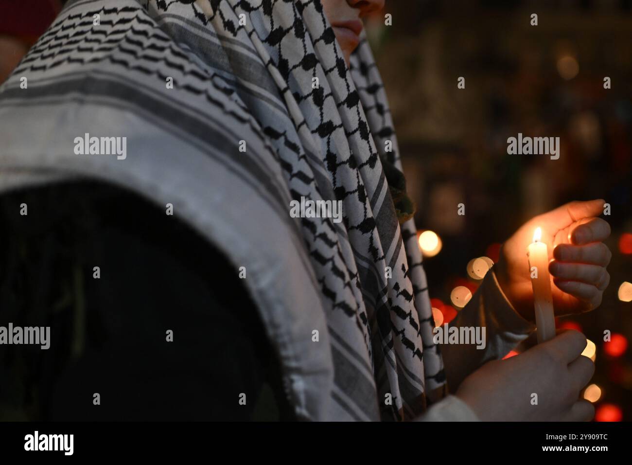 A close up on a candle at a vigil in tribute to the victims of the ...