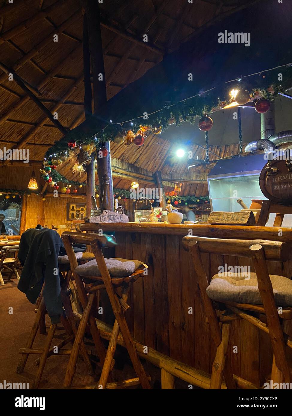 Cozy rustic bar interior decorated with festive garlands and warm ...