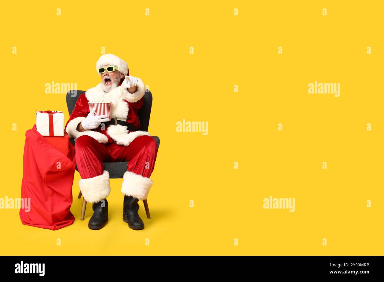 Shocked Santa Claus holding bucket of tasty popcorn and bag with gifts ...
