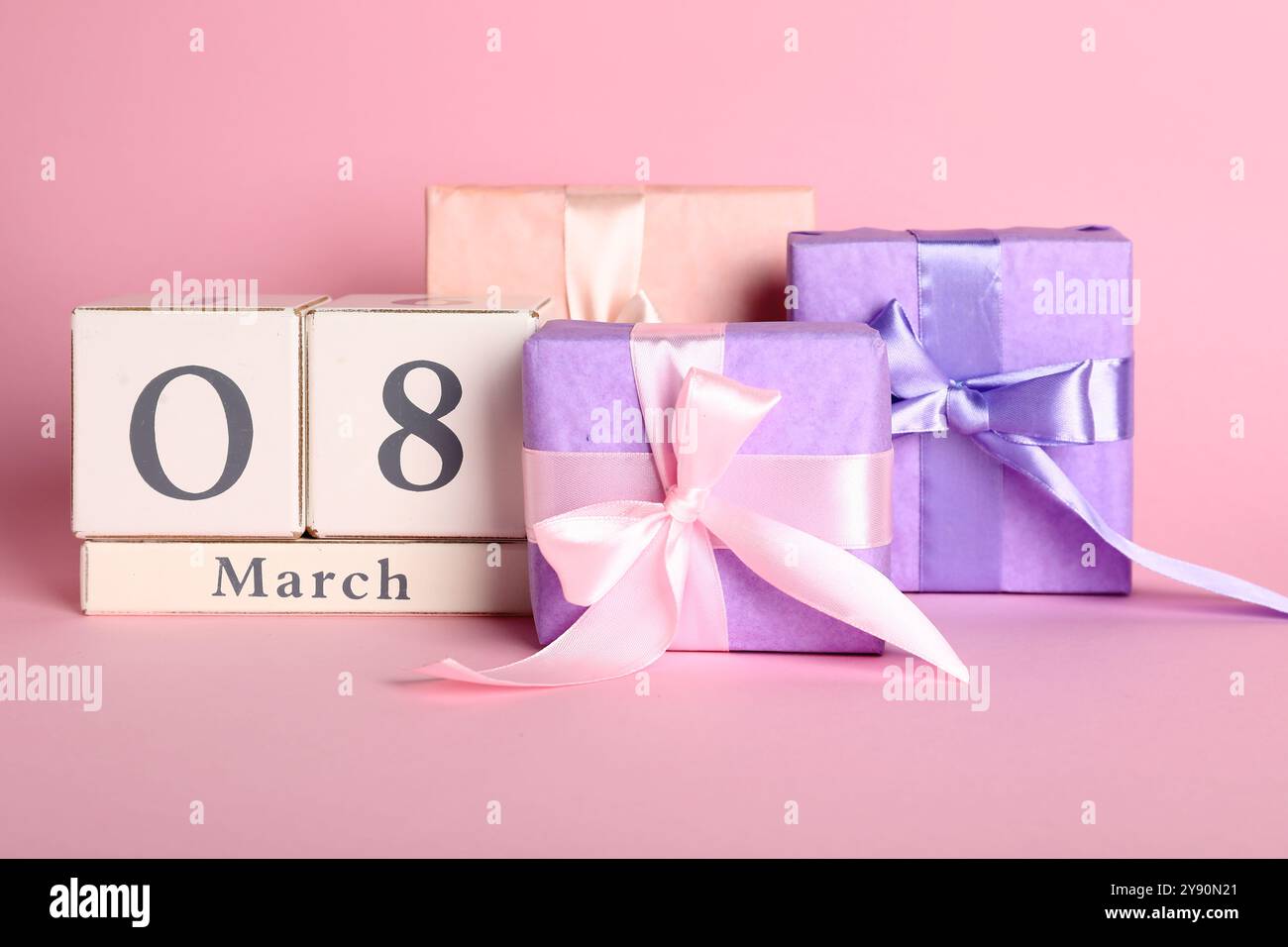 Cube calendar with date 8 MARCH and gift boxes on pink background ...