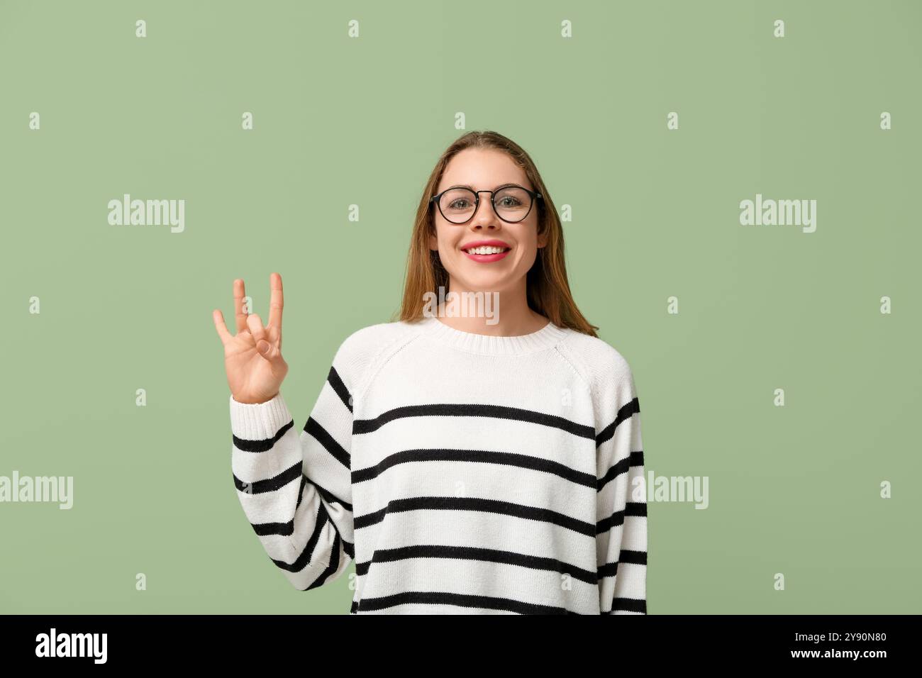 Young deaf mute woman using sign language on green background Stock ...