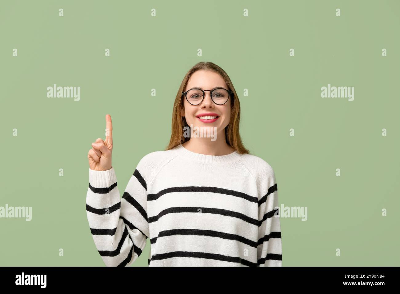 Young deaf mute woman showing numbers with sign language on green ...