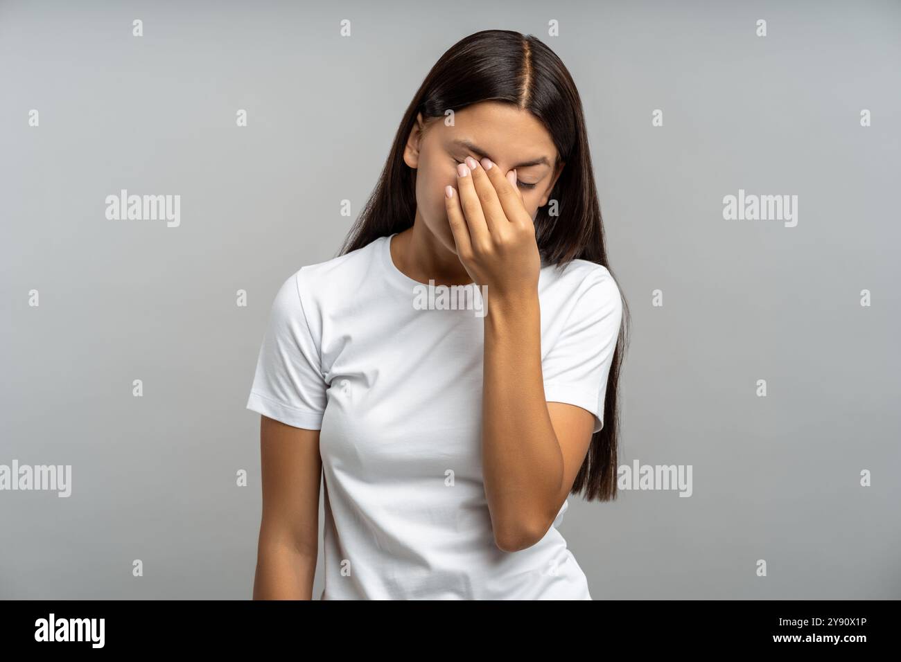 Weary, emotionally drained teenage girl rubbing tired eyes, slouched ...