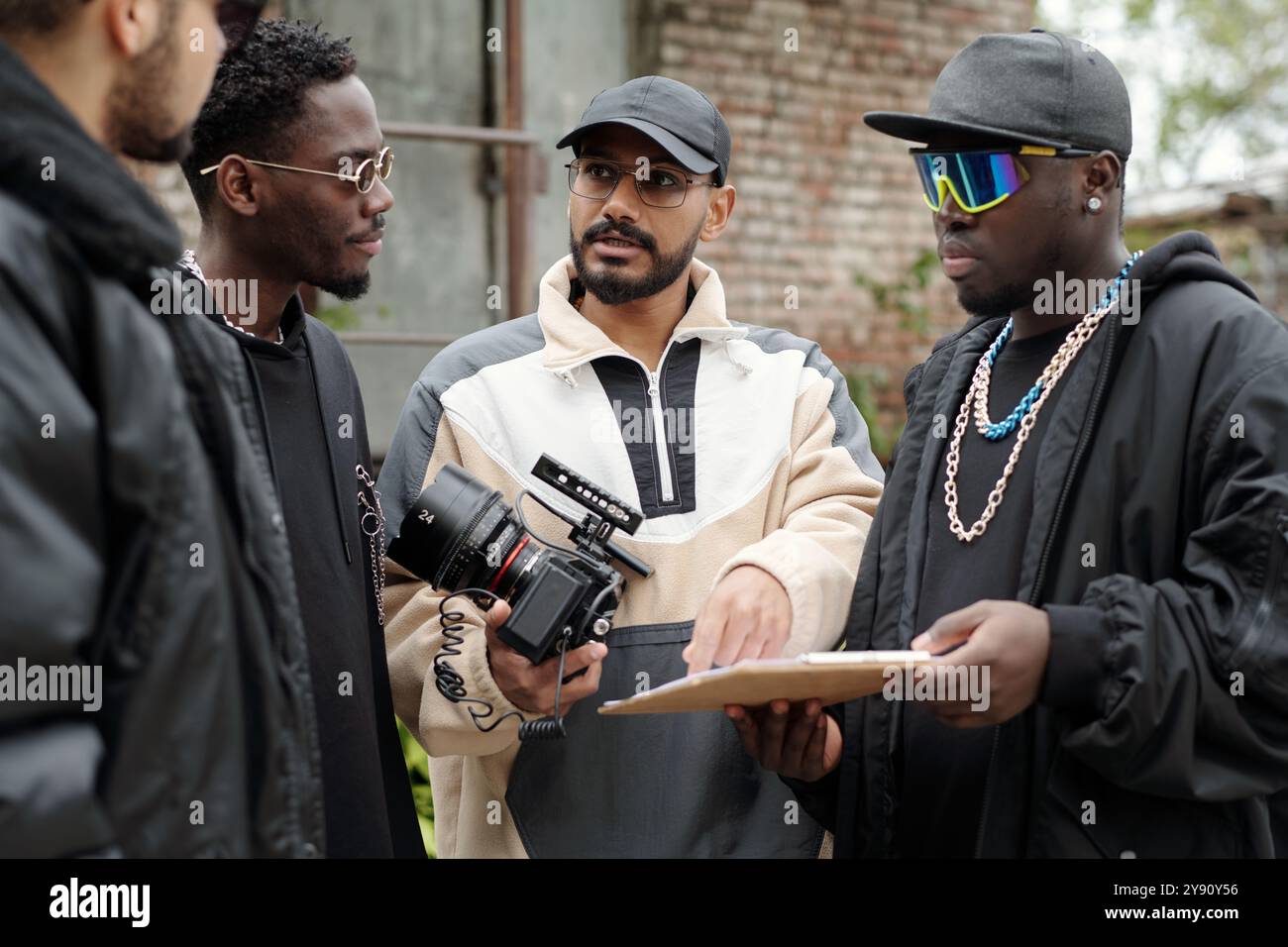 Group of men engaging in a conversation on set about film project while ...