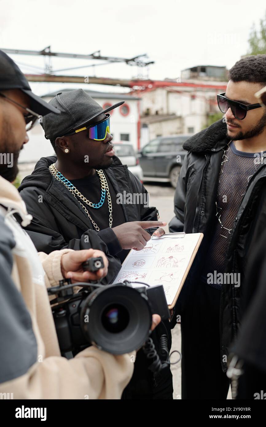 Group of people engaging in project discussion while holding documents ...