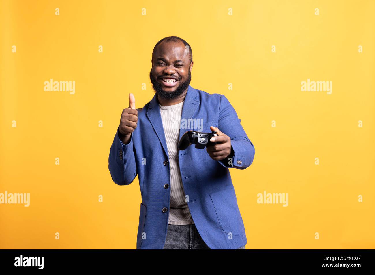 Cheerful gamer showing thumbs up sign gesturing holding controller ...