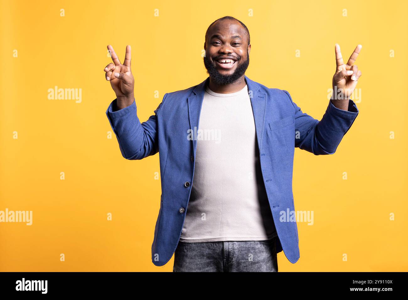Portrait of joyous african american man doing victory sign and feeling ...
