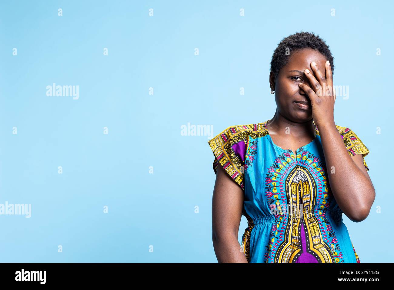 Anxious fearful woman hiding her eyes from the lens out of worry and ...