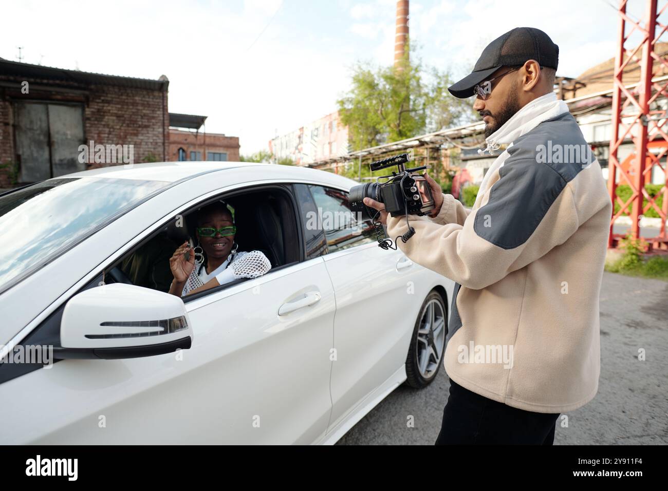 Man holding camera outside car while woman sitting inside smiling ...