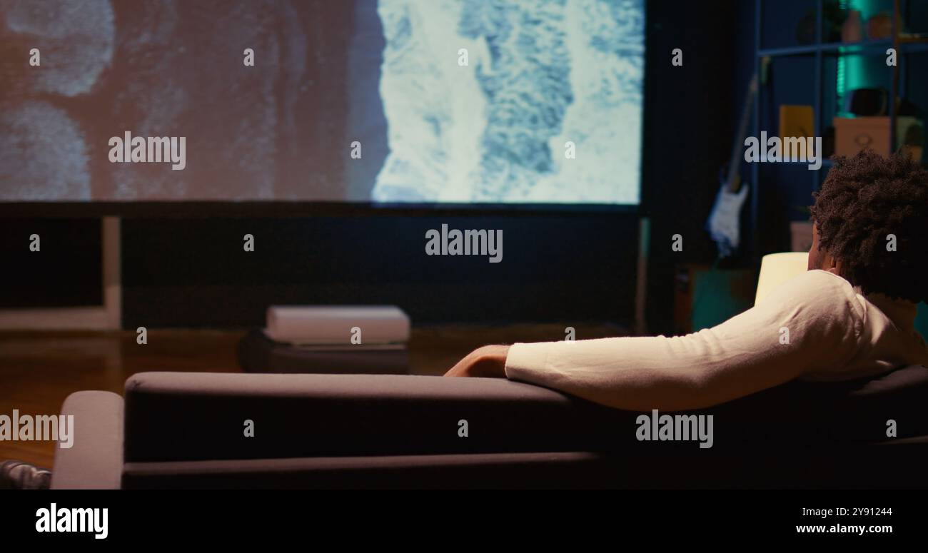 Zoom in on man mesmerized by nature documentary with beautiful ...