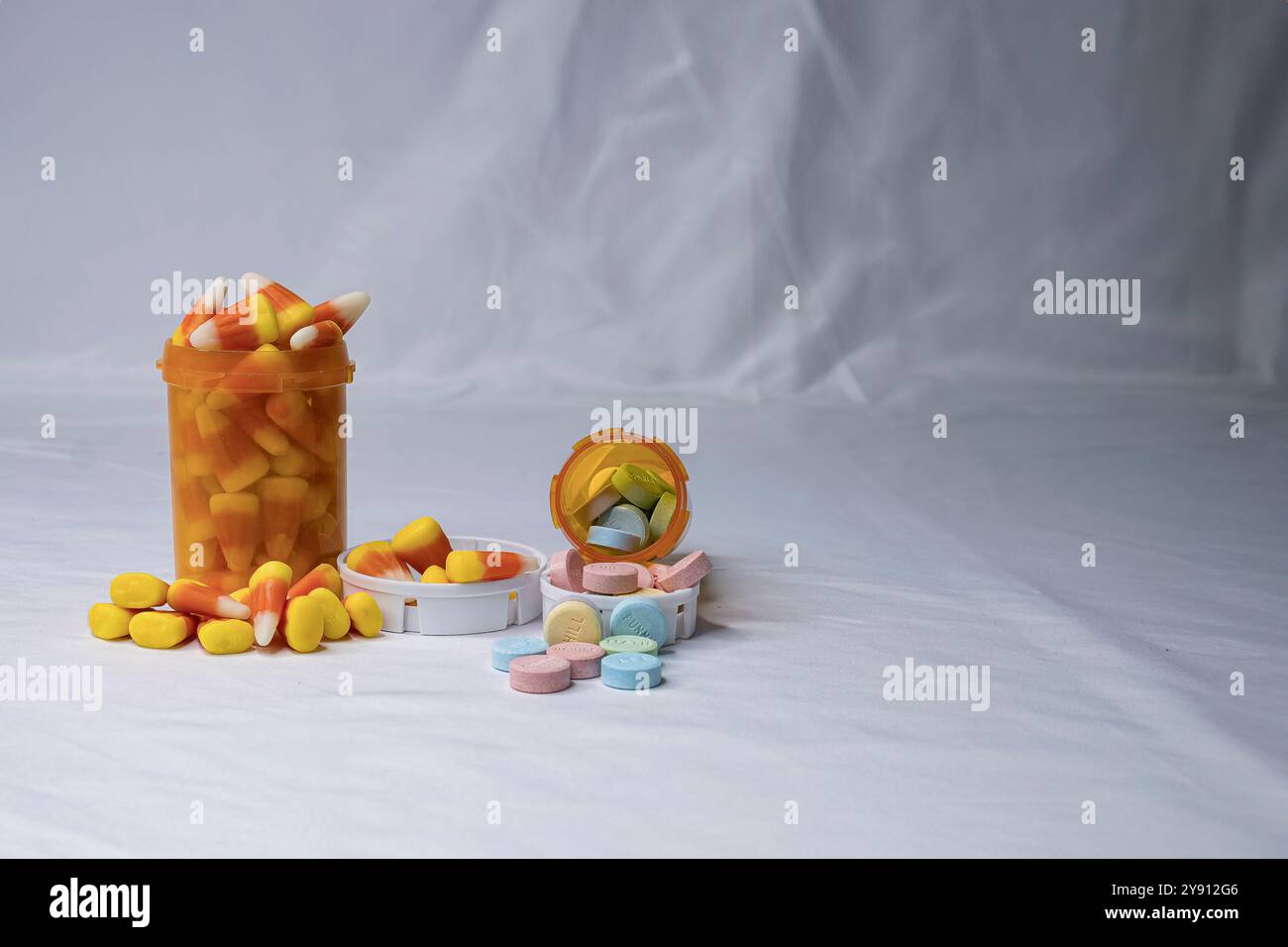 Two overflowing bottles of pills illustrate the concept of drug misuse ...