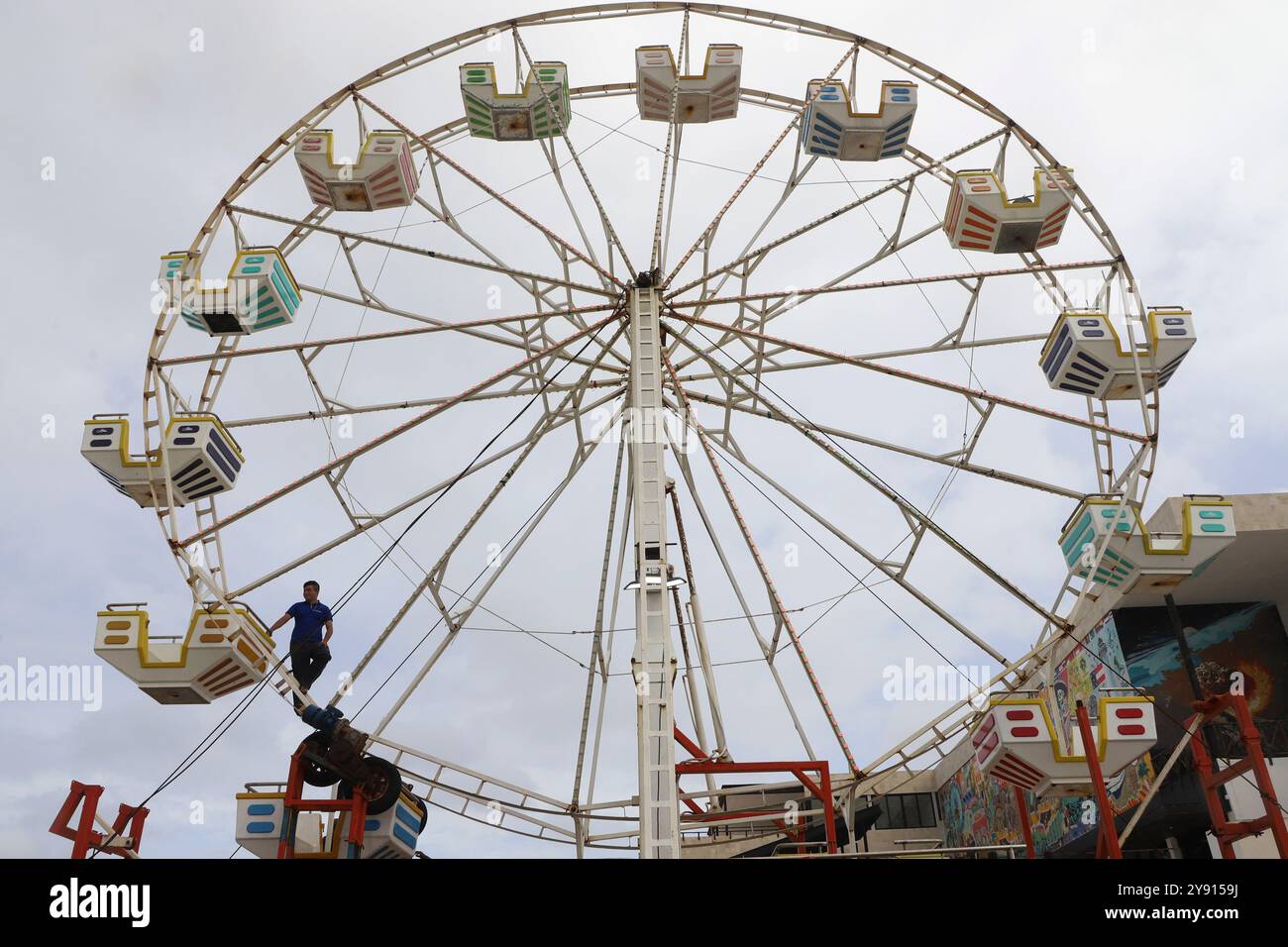 A man ties up a ferris wheel to protect it from Hurricane Milton, in ...