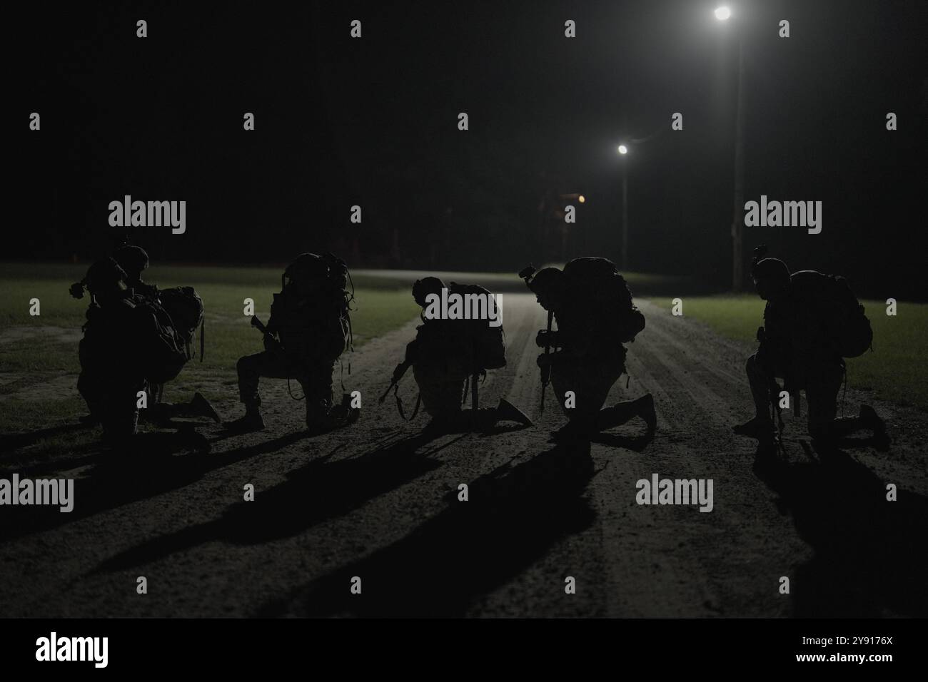 Soldiers taking part in the Army Best Squad Competition wait to load ...