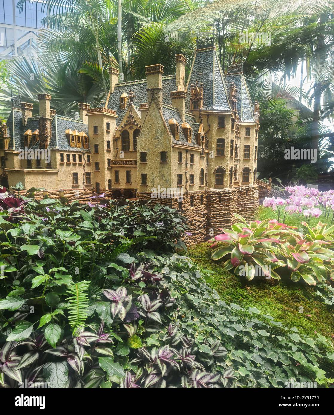 Miniature castle model surrounded by lush greenery and flowers Stock ...