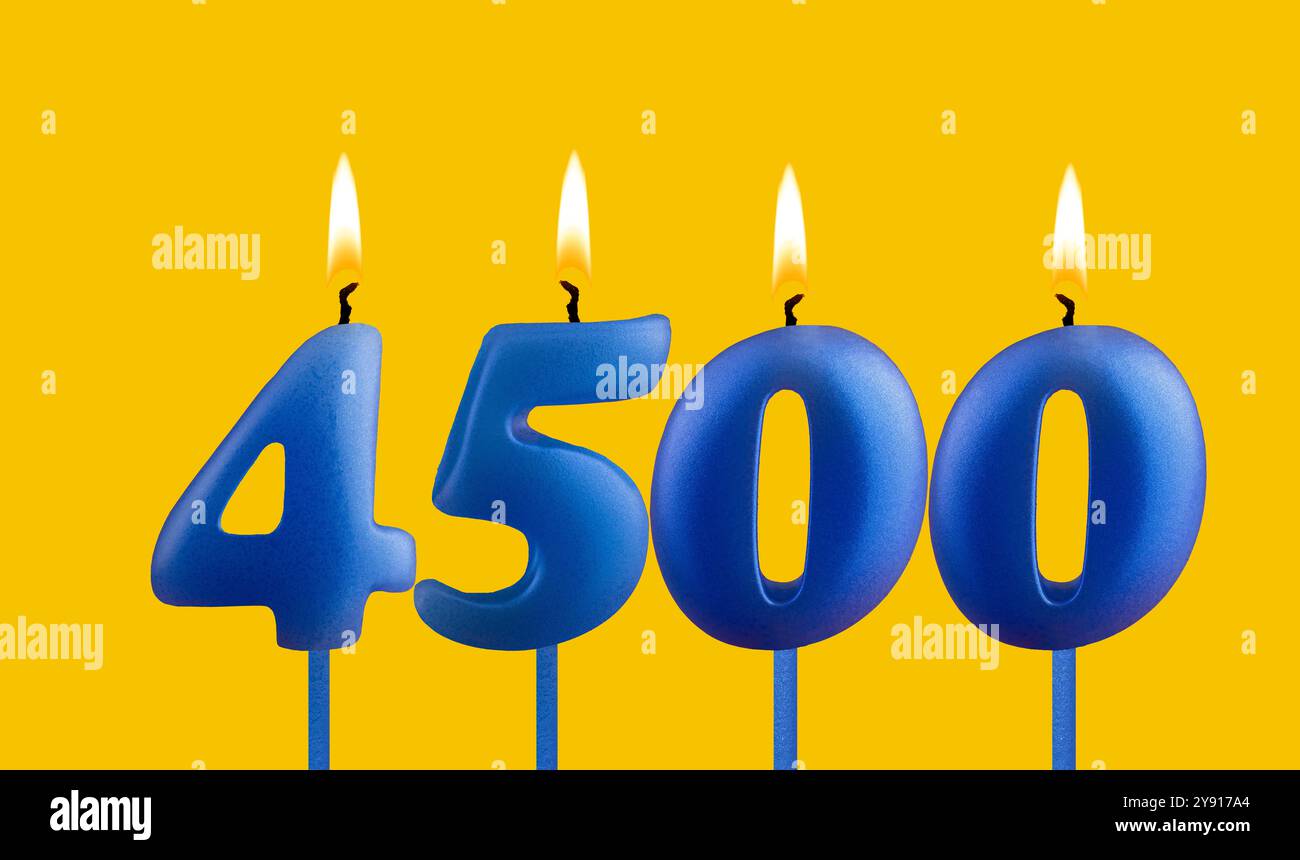 Blue birthday candle on yellow background - Number 4500 Stock Photo - Alamy