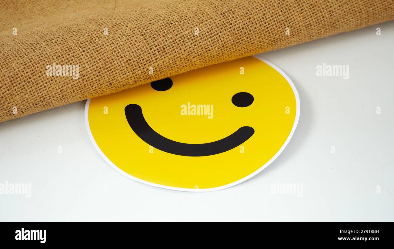 A pink smiling emoji tucked behind a pink background Stock Photo - Alamy