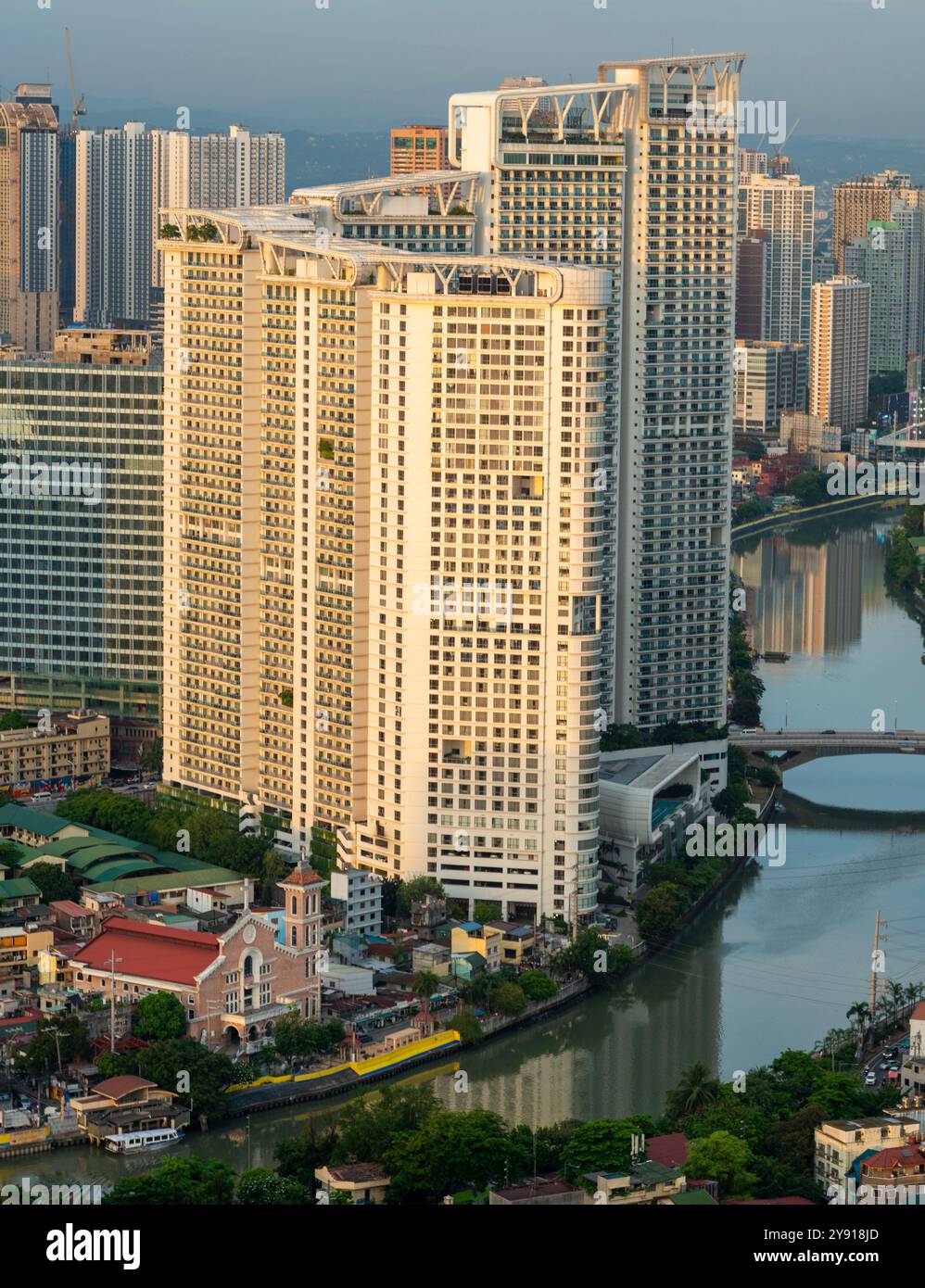 A pretty pink traditional Philippines church sits below massive modern ...