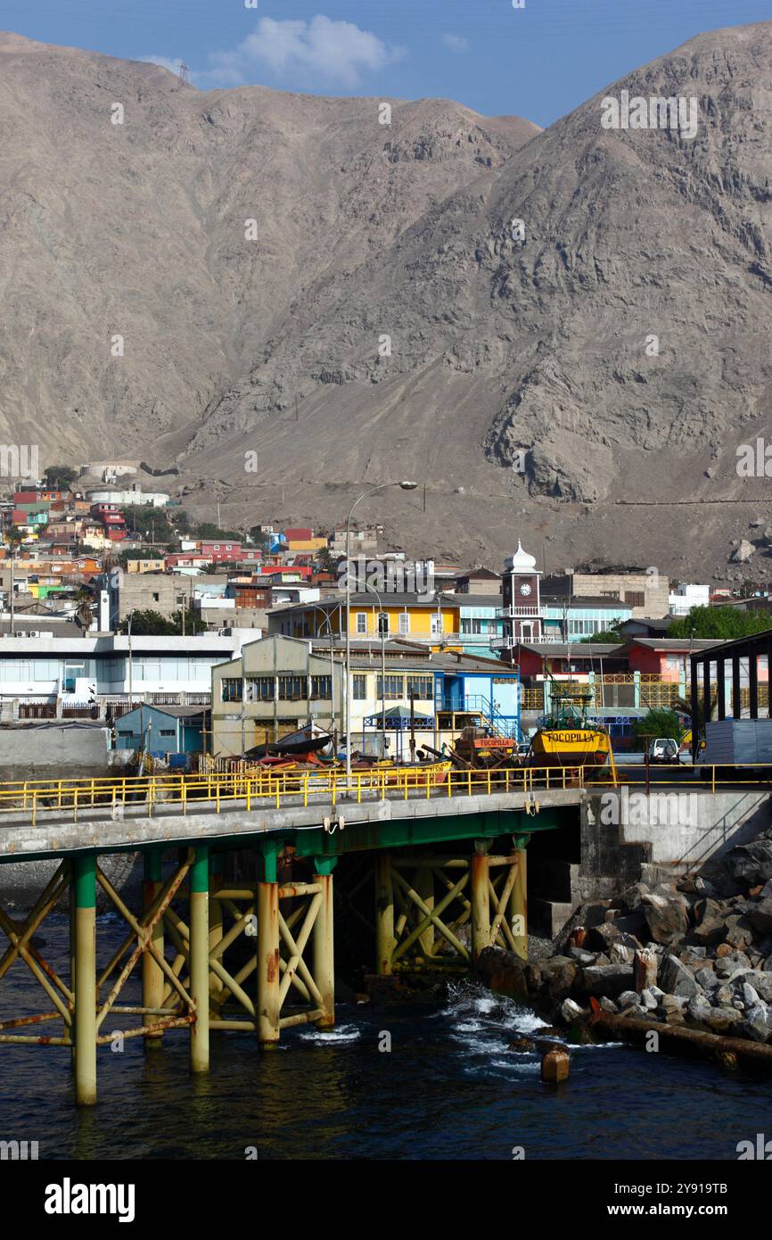 View of part of pier and quay of port, Coya Sur clock tower in ...