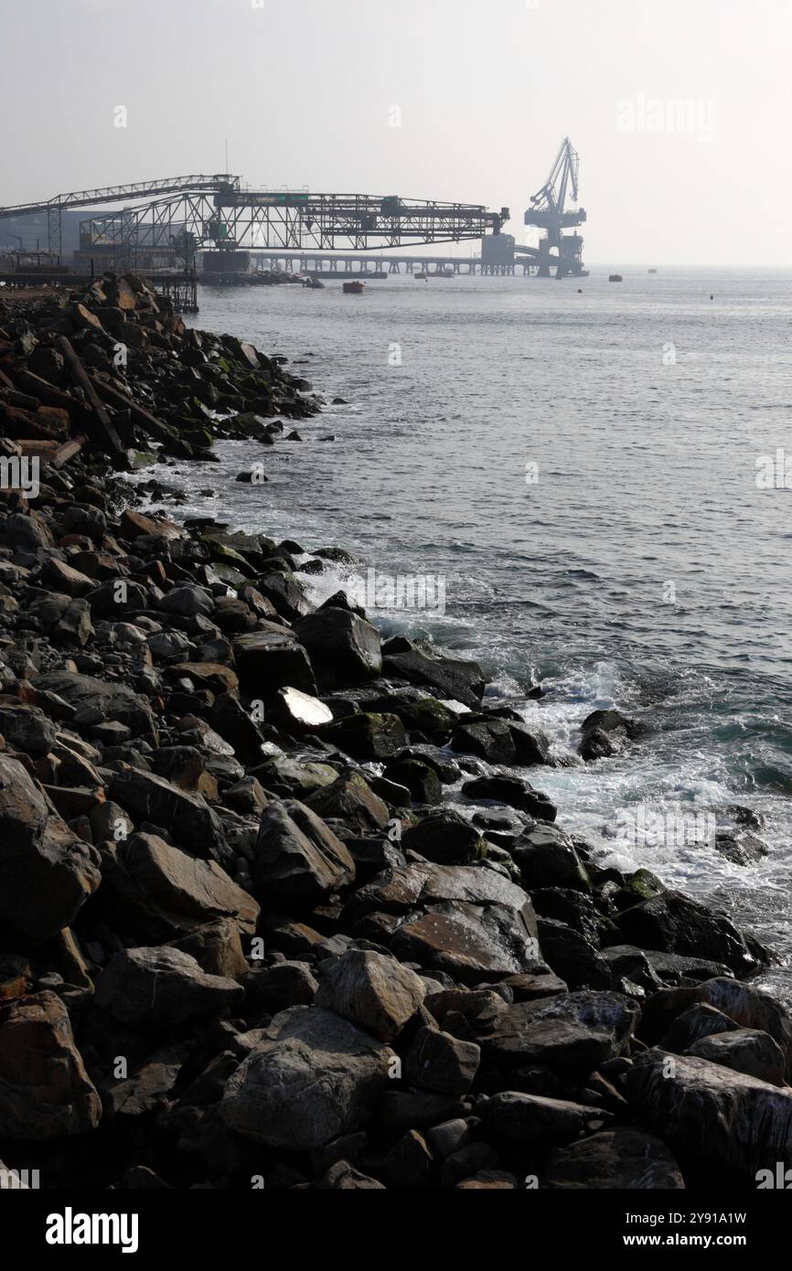 Jetties and gantry cranes for loading minerals onto ships in port and ...
