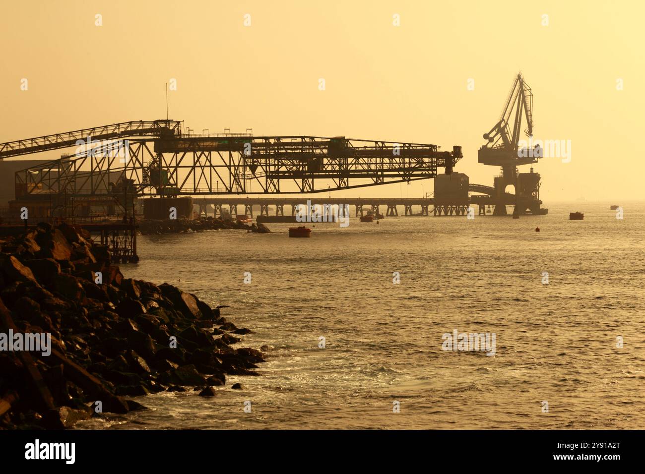 Jetties and gantry cranes for loading minerals onto ships in port and ...