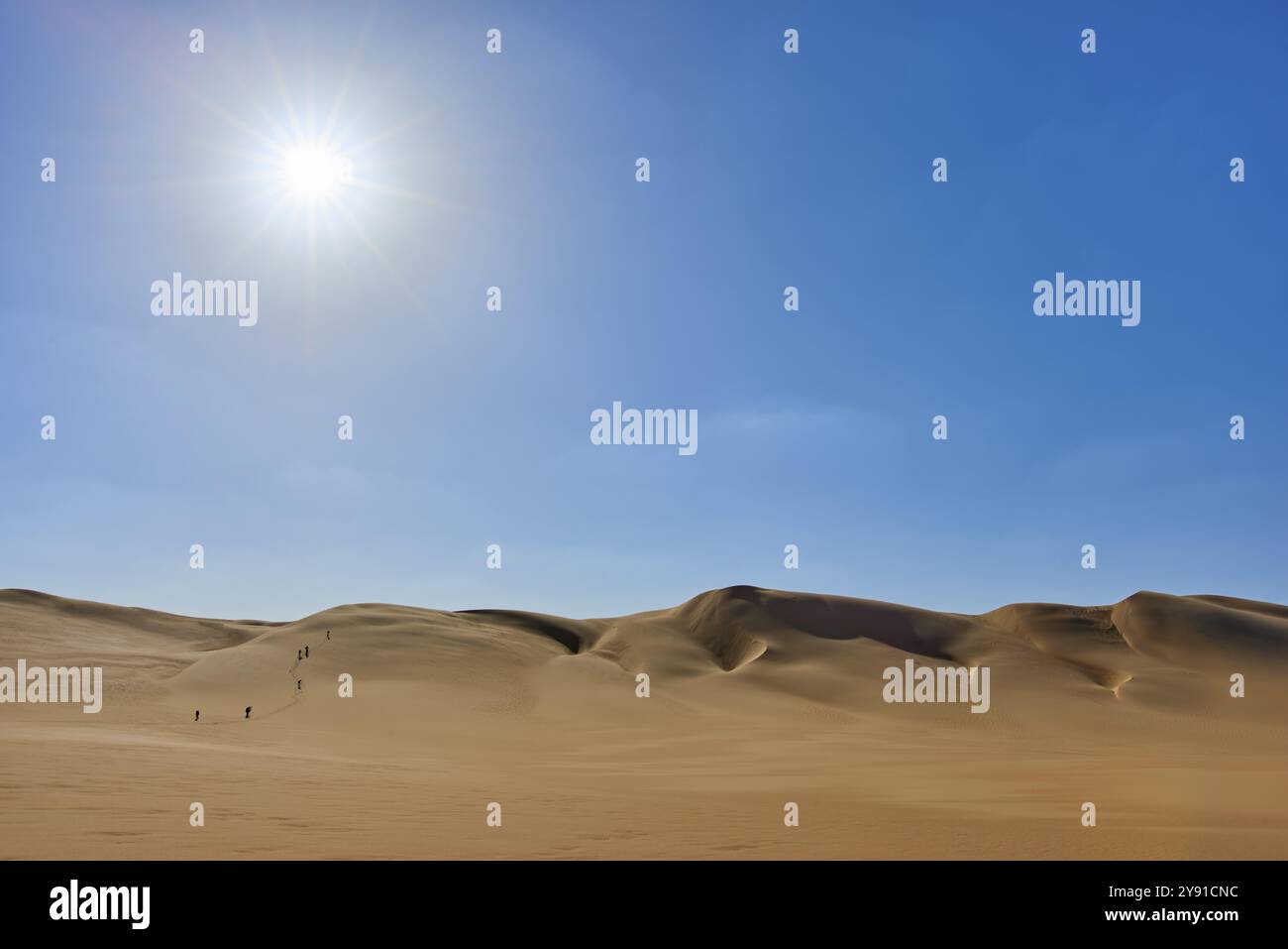 Sunny desert landscape with sand dunes tourist group, under clear blue ...