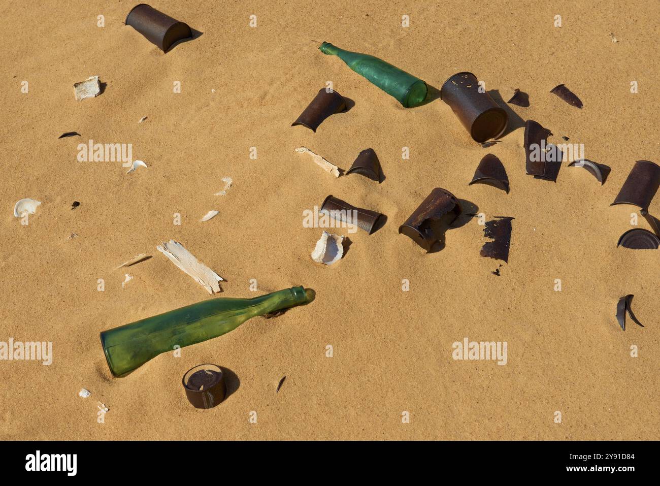 Broken glass bottles and rubbish on sand showing pollution in a desert ...
