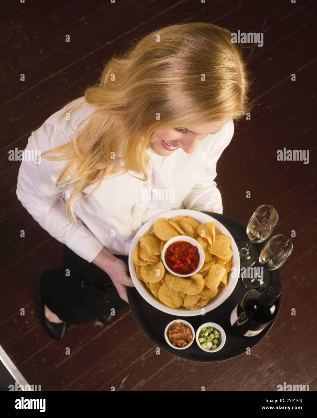 Young server brings the appetizer on a tray Stock Photo - Alamy