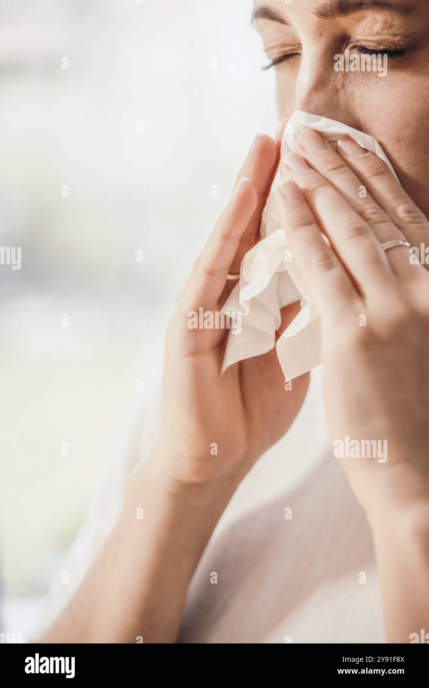 Woman in bright light uses a paper towel to blow her nose, 'symbolic ...