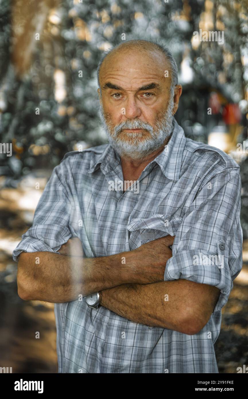 Man, senior, half portrait, camera view, serious look, bad mood, grey ...