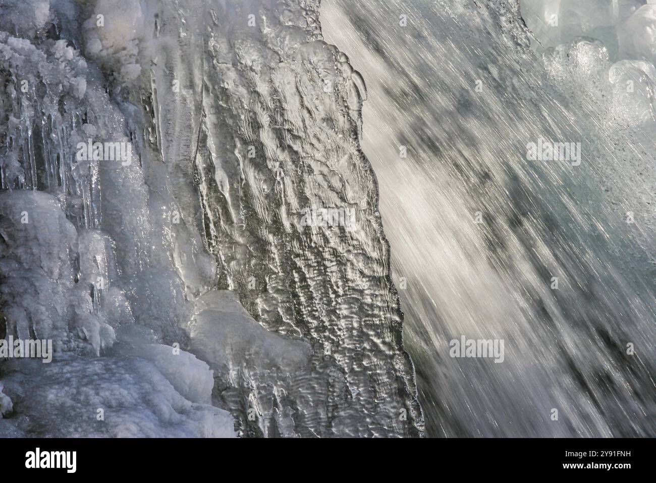 Frozen waterfall with complex ice structures and flowing water ...