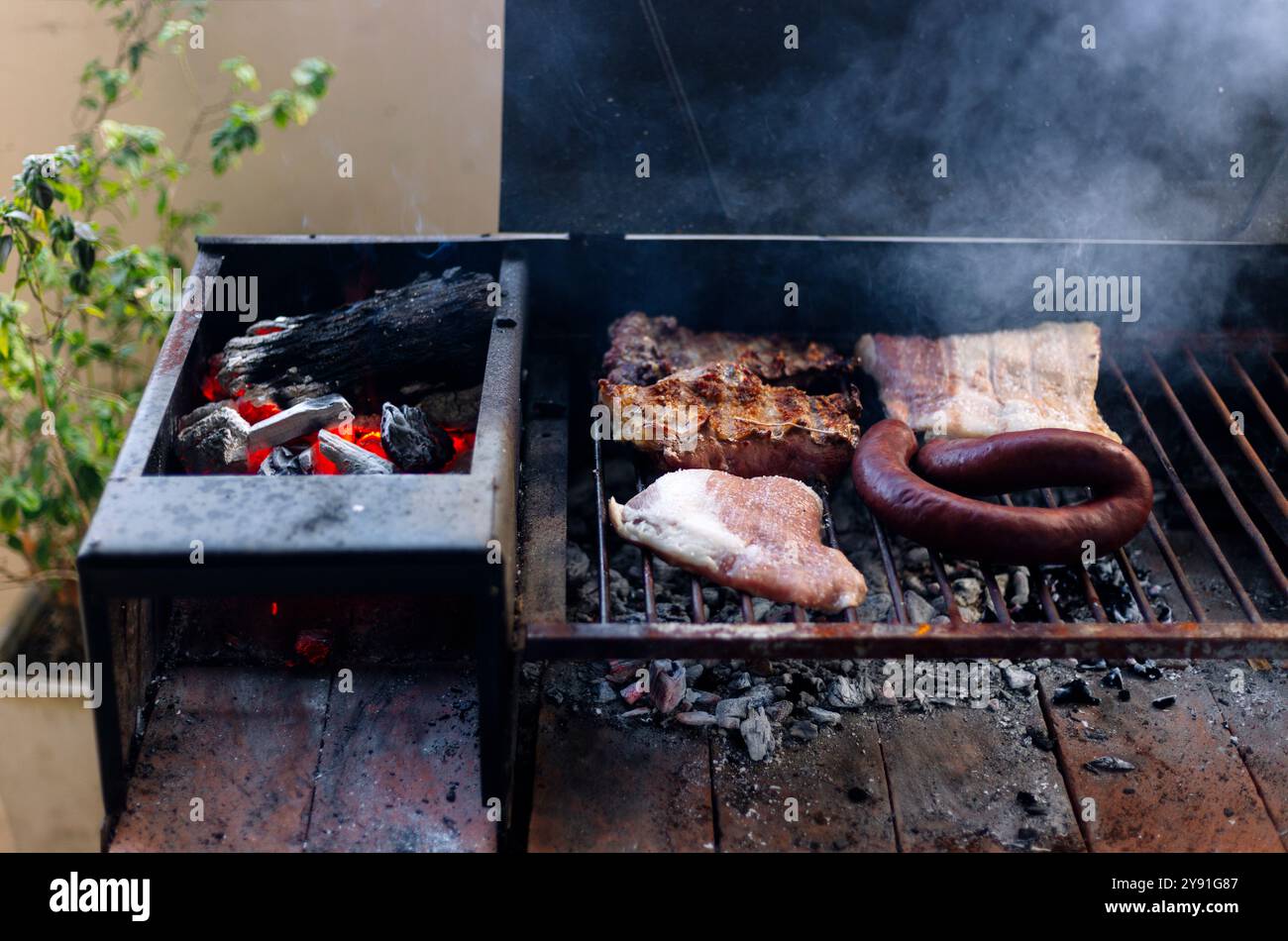 Making a barbecue with a portbale grill in the balcony of apartment ...