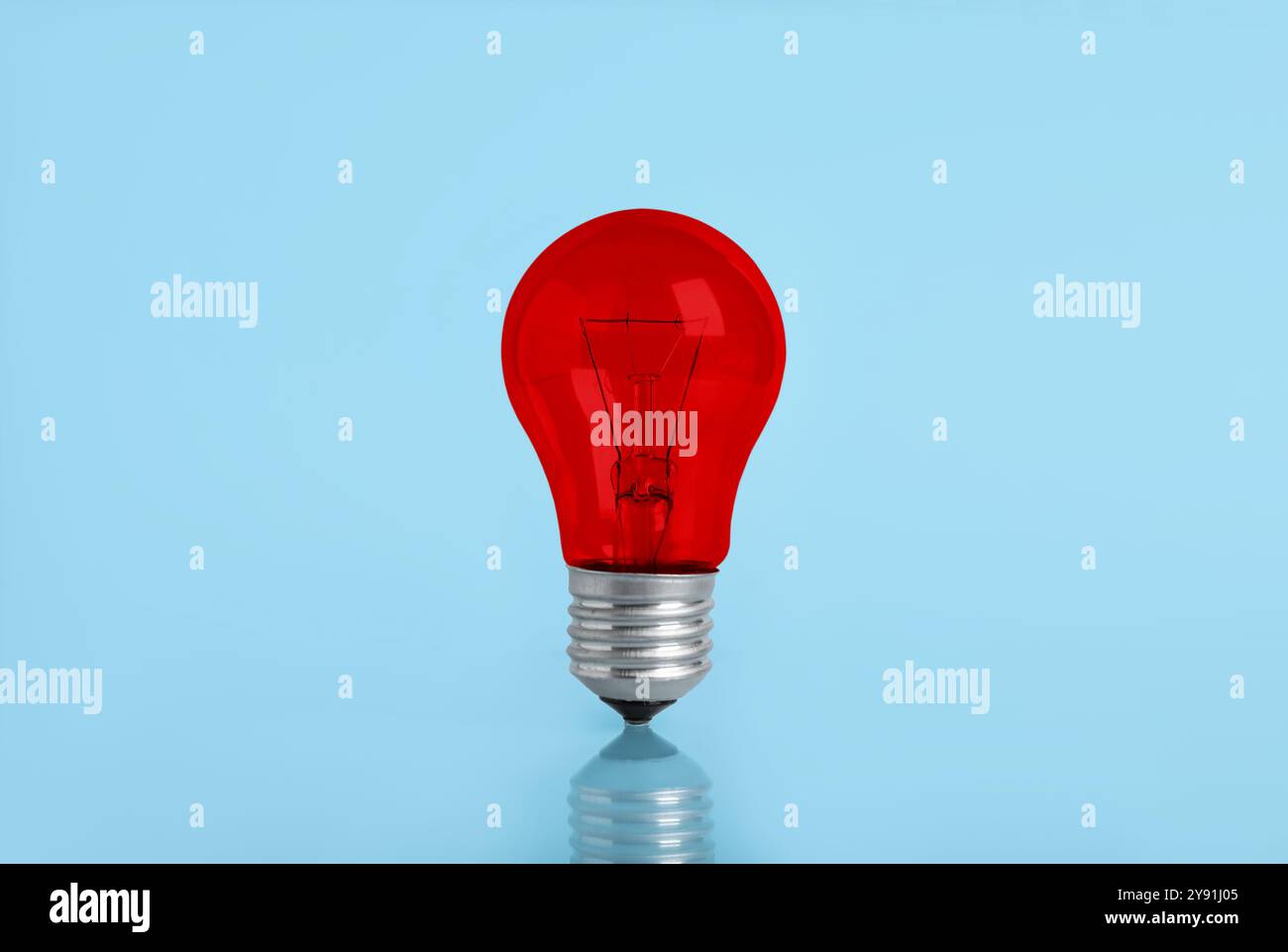 One red bulb on light blue background Stock Photo - Alamy