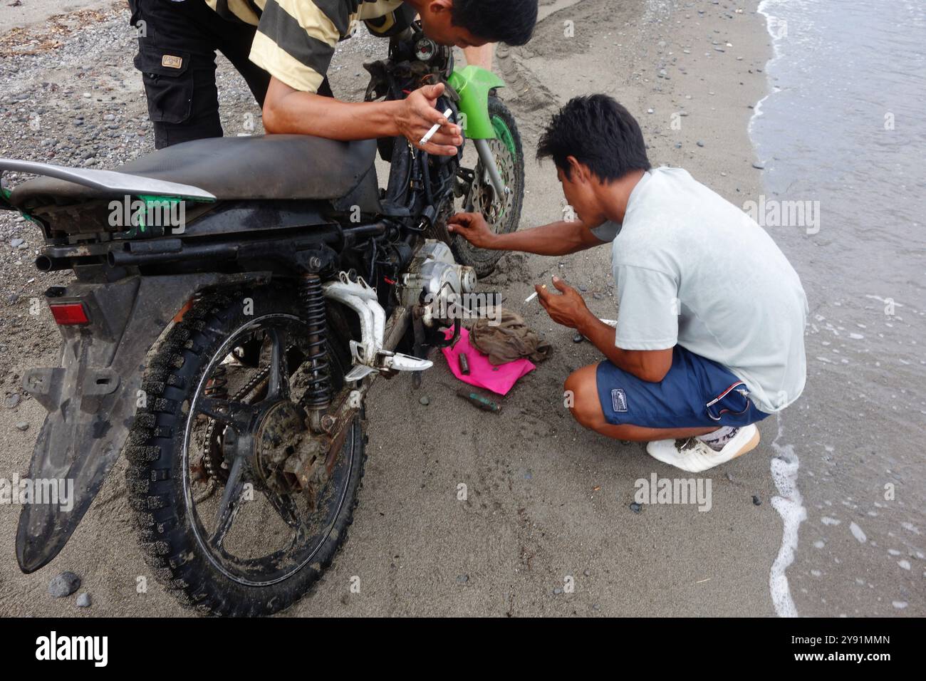 Motorbike repairs on the beach, Una Una Island, Togean Islands ...