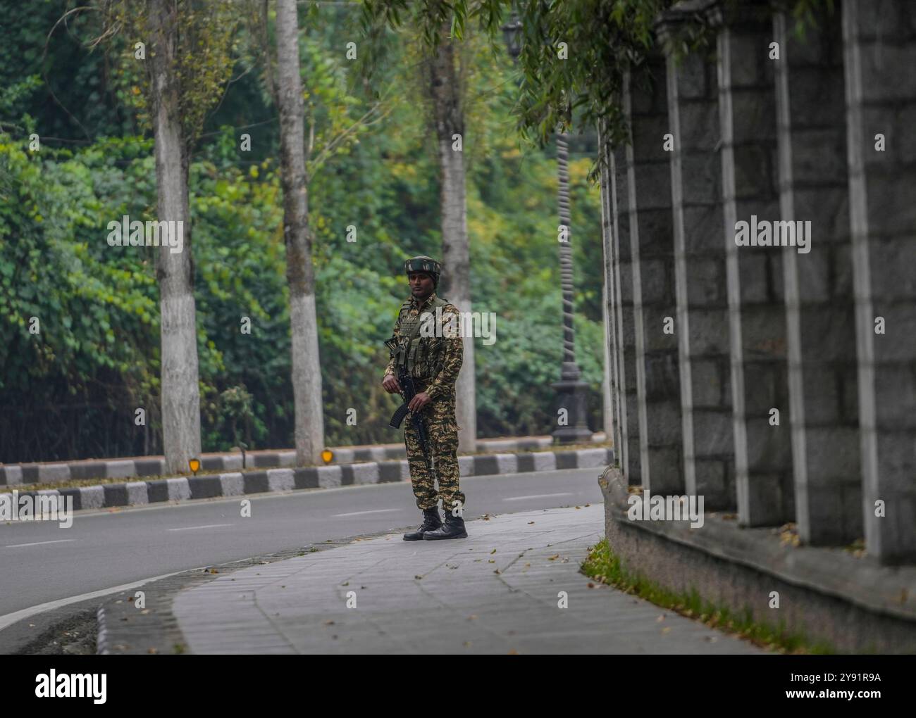 An Indian paramilitary soldier guards outside a vote counting center ...
