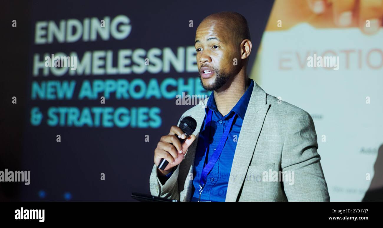 African man, speech and stage at conference for homeless crisis with ...