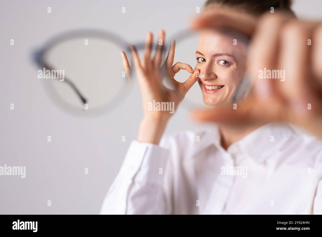 Poor vision concept, woman with poor vision holding glasses in front of ...