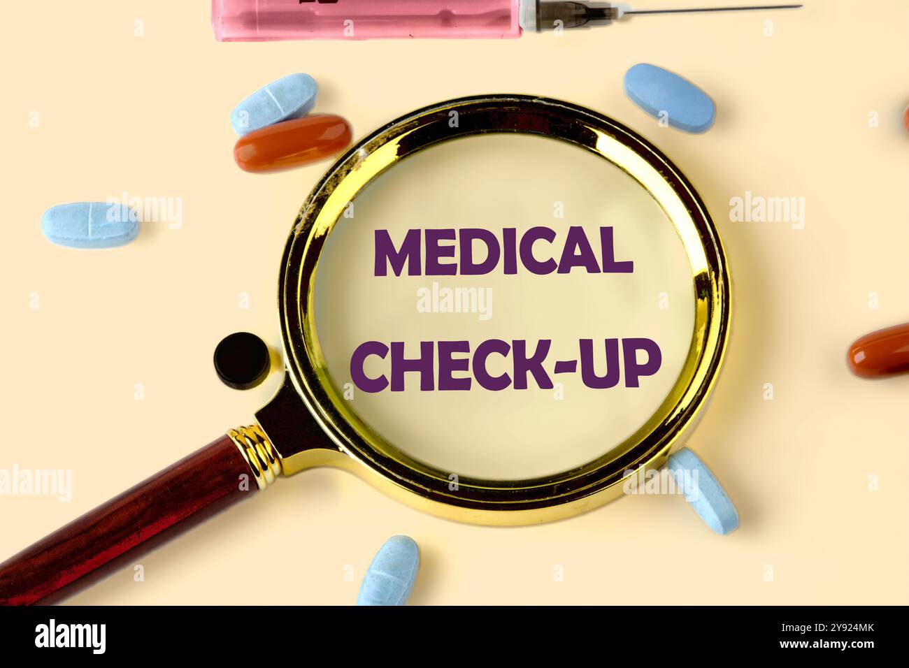MEDICAL CHECK-UP words written through a magnifying glass on a yellow ...