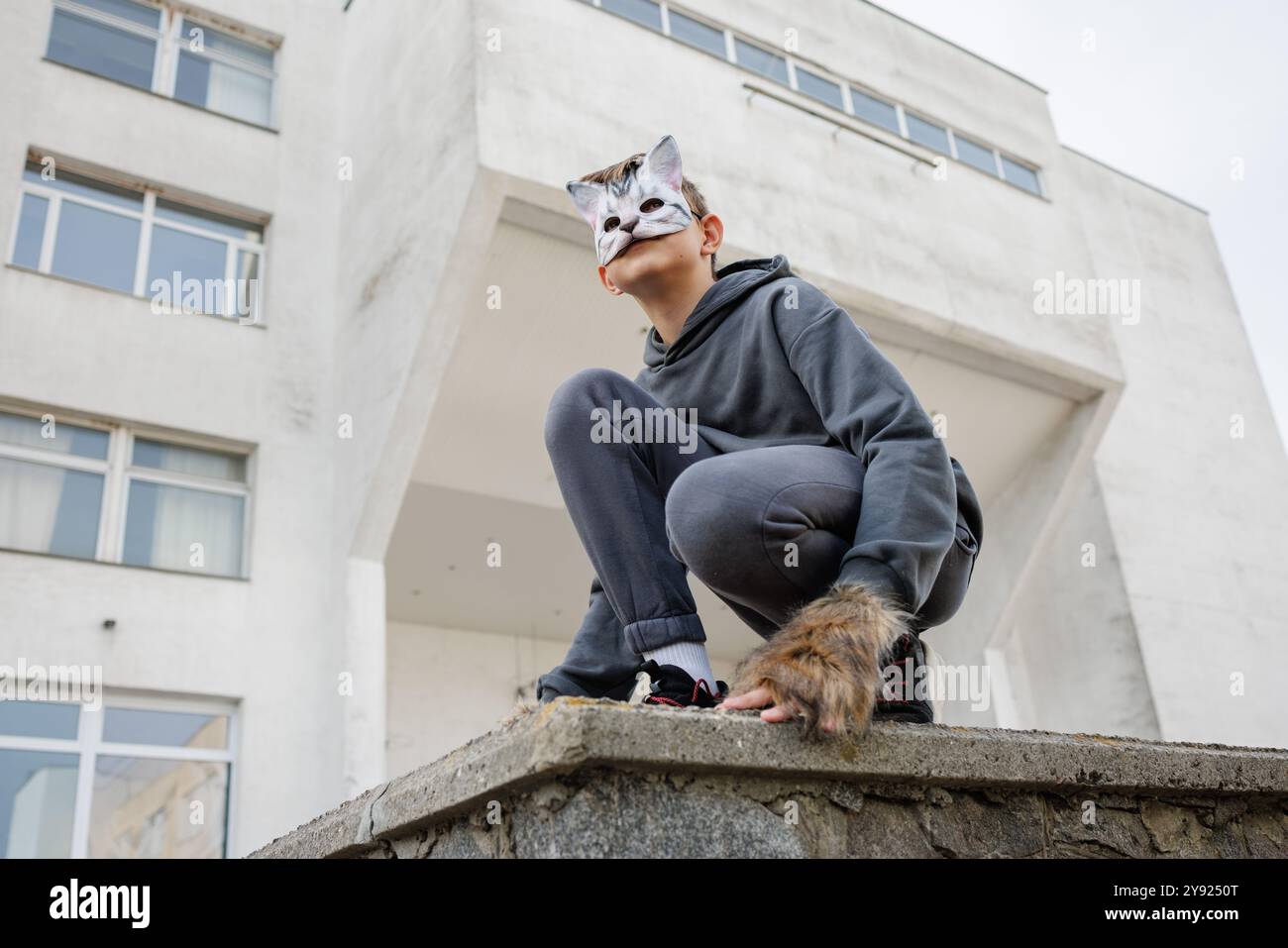 quadrobics teenager in cat mask sits on all fours in park, quadrobika ...