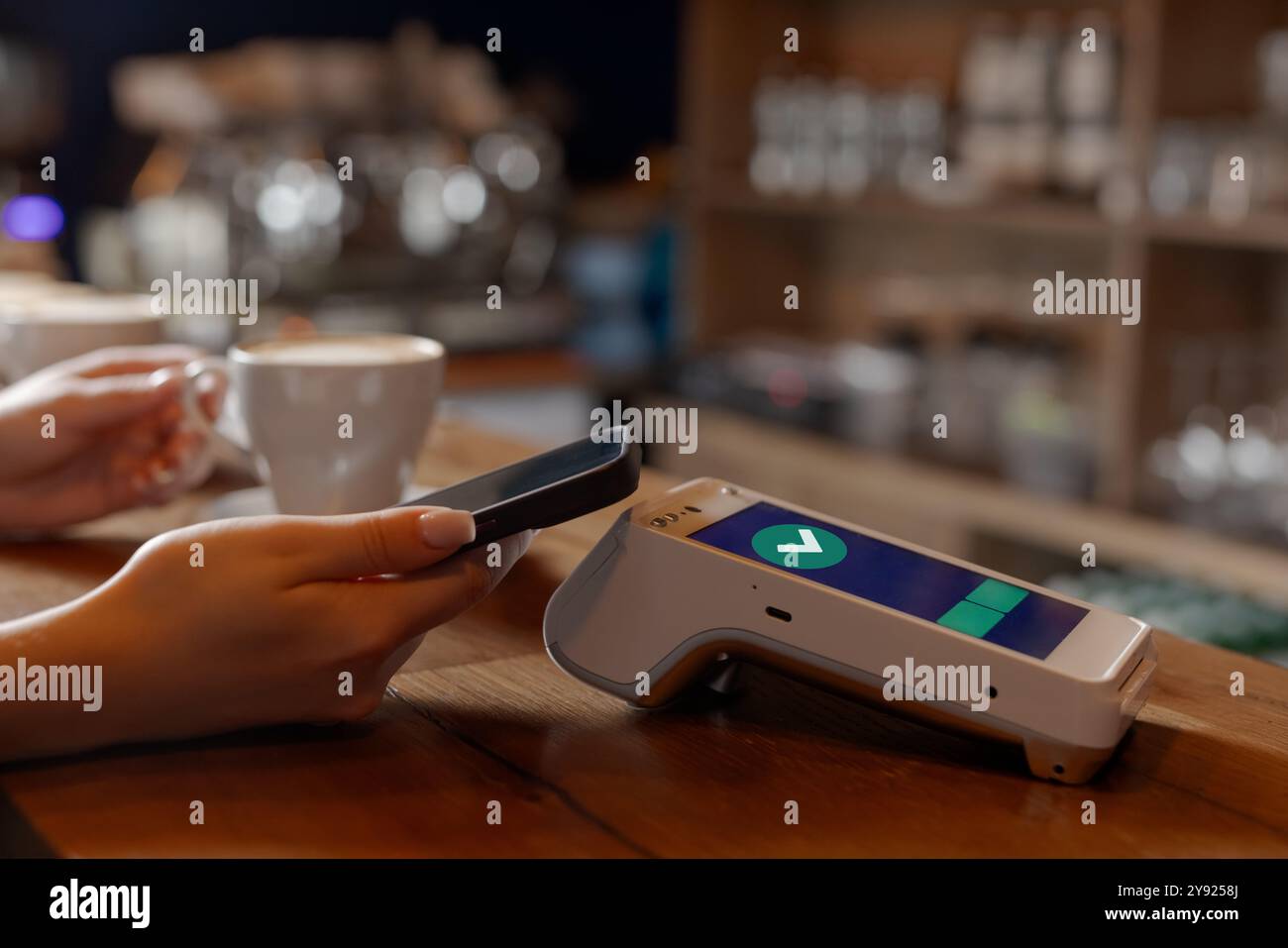 customer makes contactless NFC payment by phone through terminal in ...