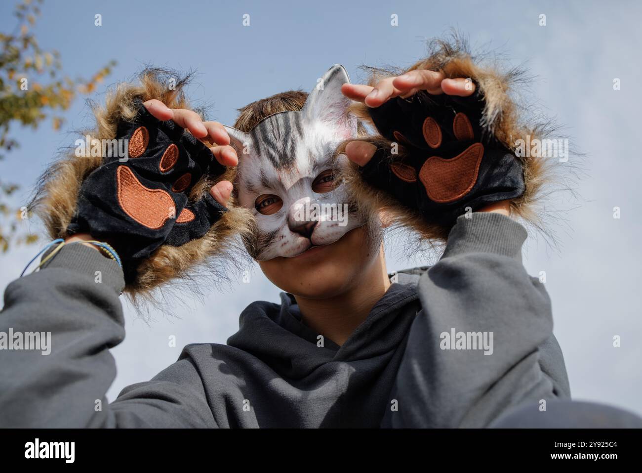 quadrobics teenager in cat mask sits on all fours in park, quadrobika ...