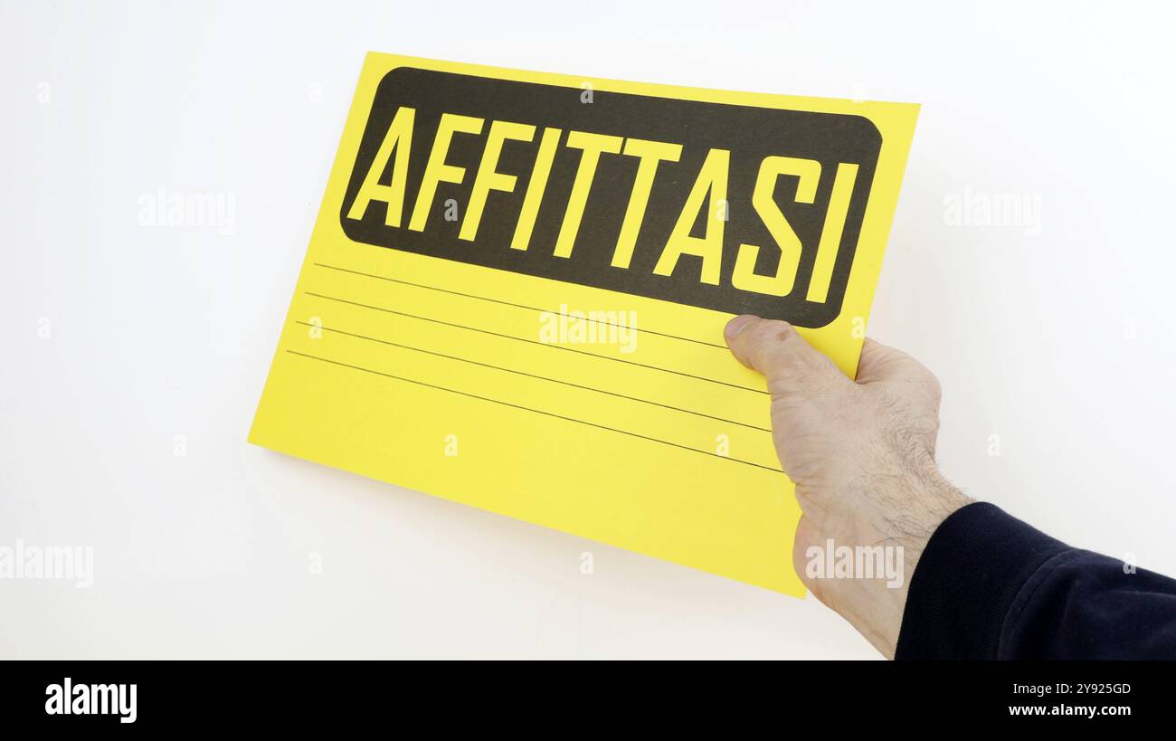 FOR RENT sign in Italian with yellow cardboard for writing, copy space ...