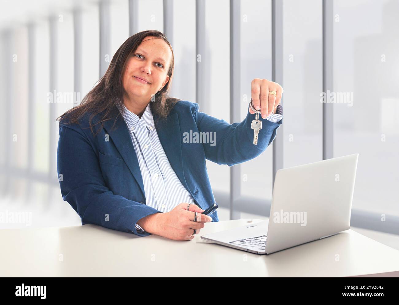 estate agent woman in front of window background Stock Photo - Alamy