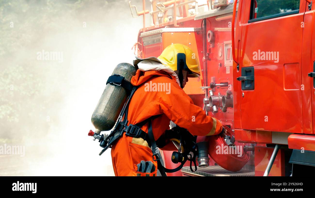 Firefighter fighting with flame using fire hose chemical water foam ...
