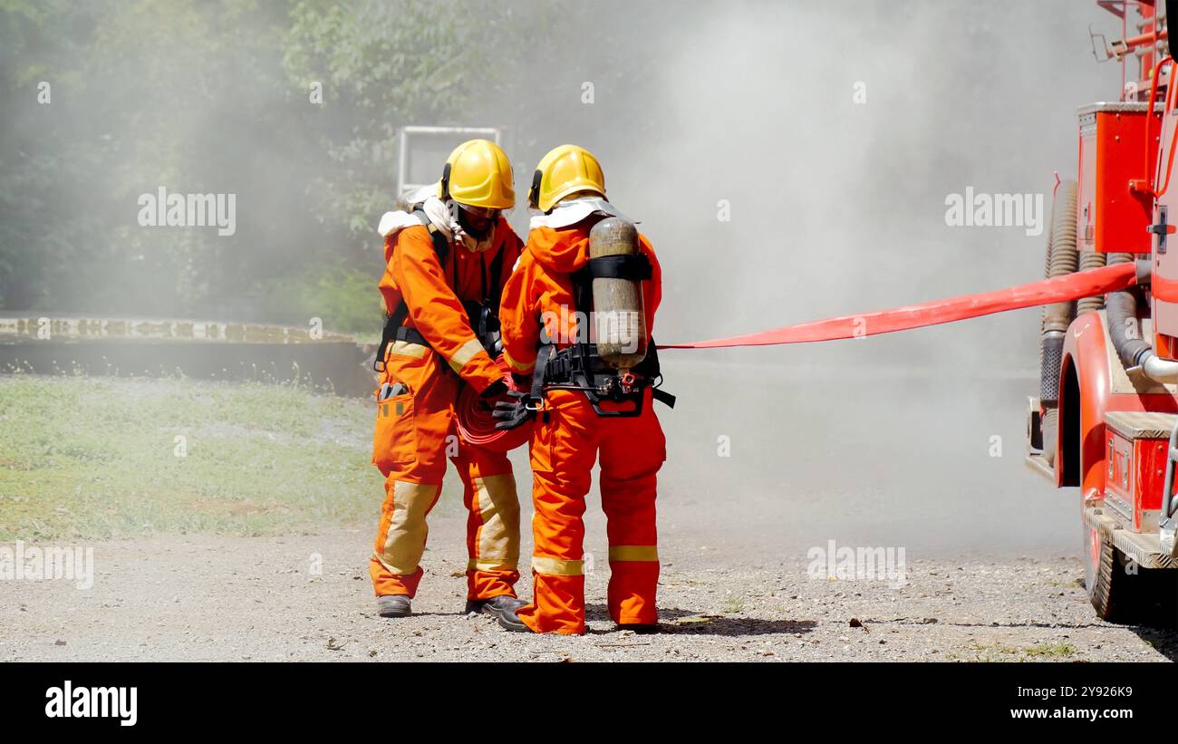 Firefighter fighting with flame using fire hose chemical water foam ...