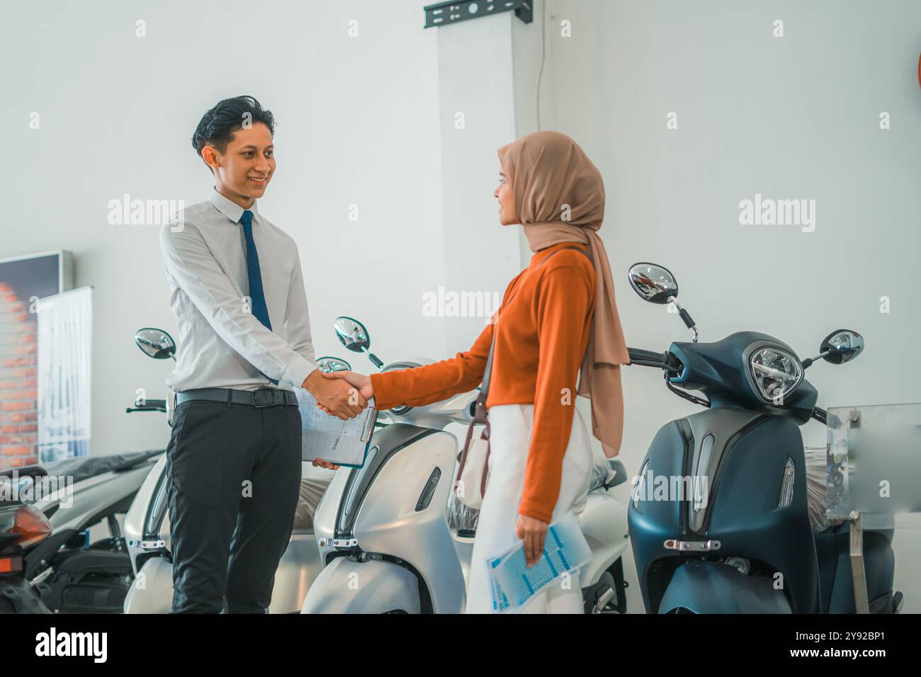 motorcycle salesman with a veiled woman in a motorcycle showroom Stock ...