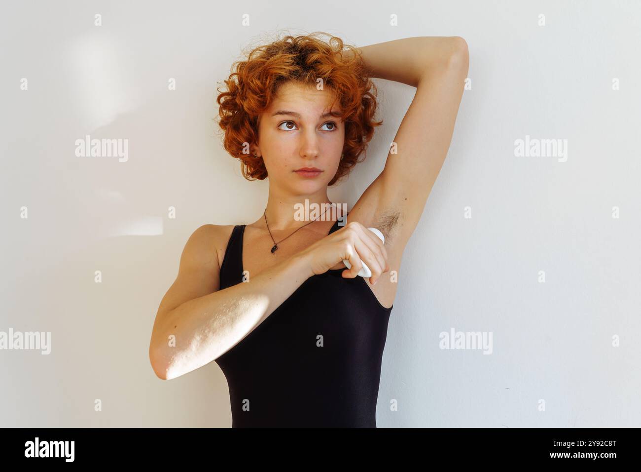 young woman uses hygiene product, roll-on deodorant Stock Photo - Alamy