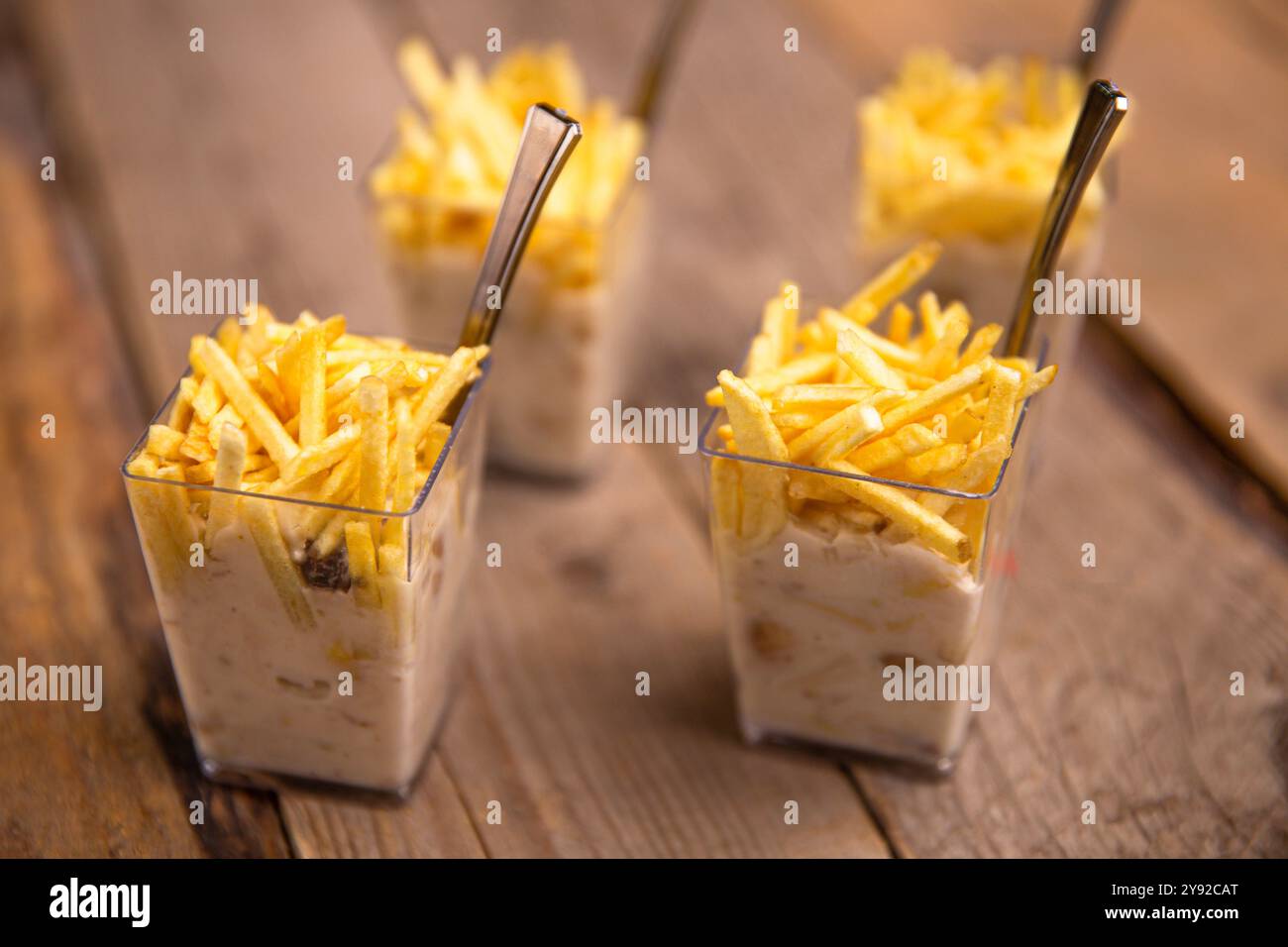 Creative appetizer with crispy French fries served in clear glass ...