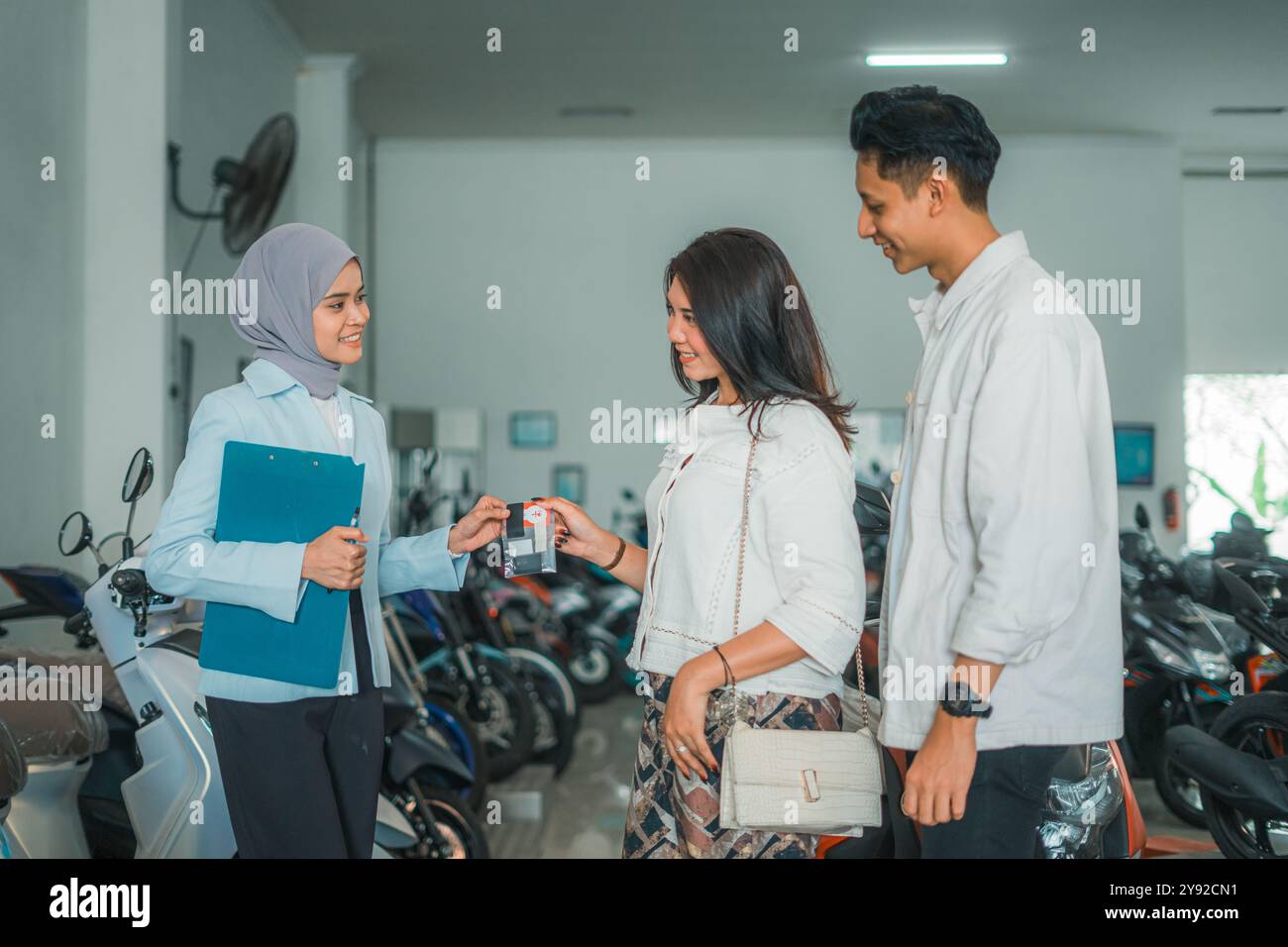 veiled woman waitress handing over a new motorcycle ownership sign ...