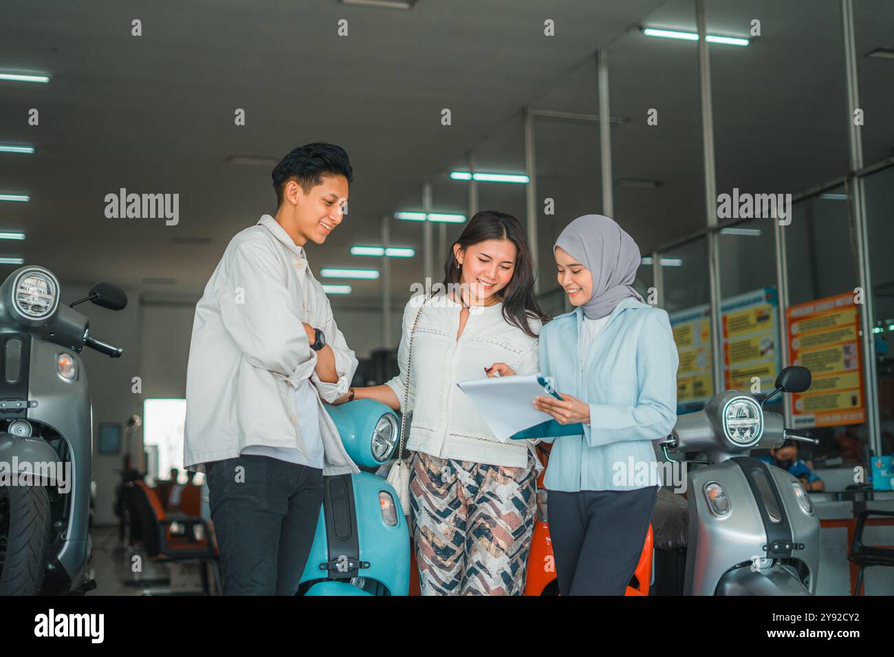 veiled saleswoman explaining to a woman and her boyfriend about ...
