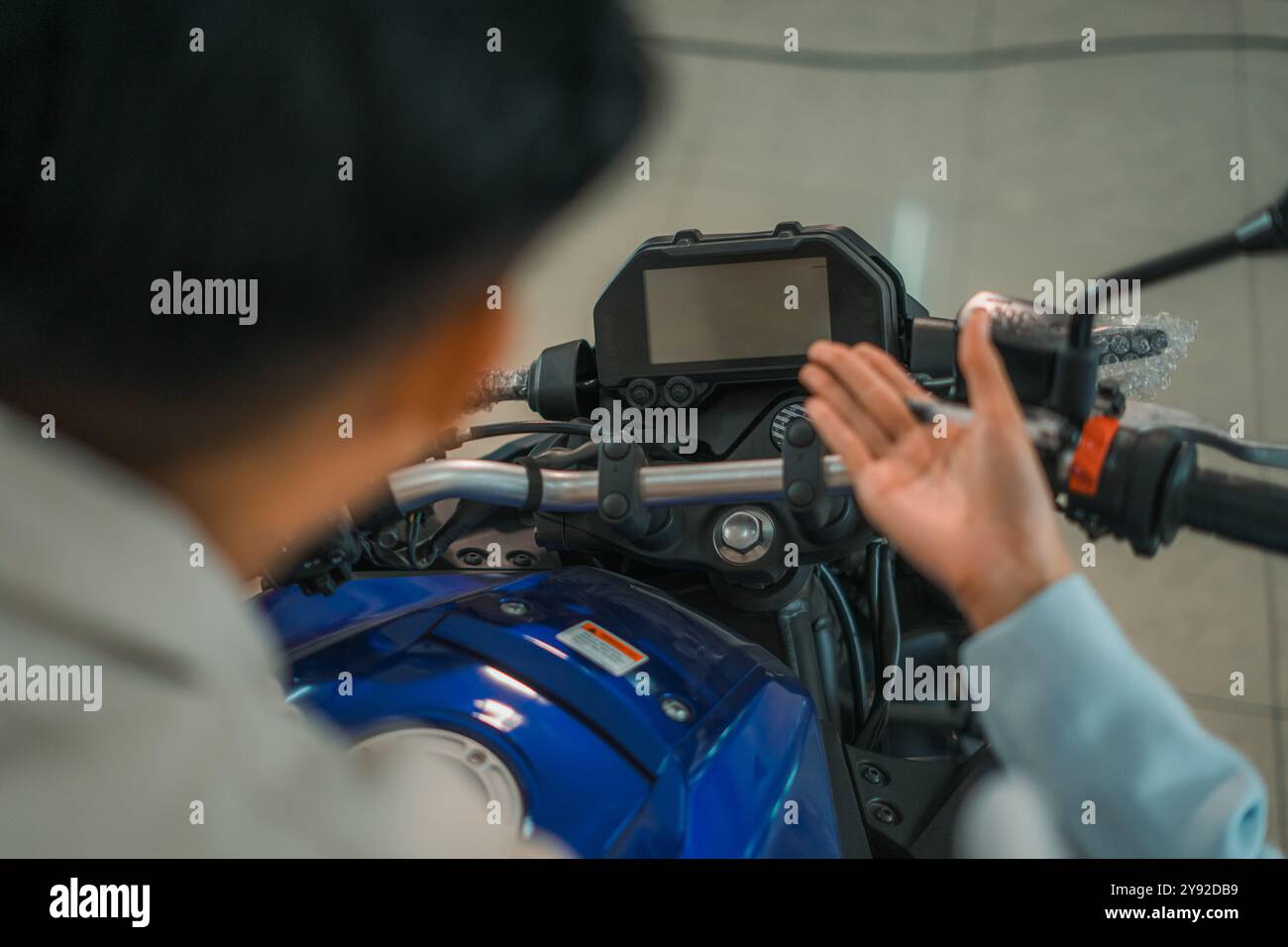 saleswoman's hand shows a motorcycle speedometer screen to a man Stock ...